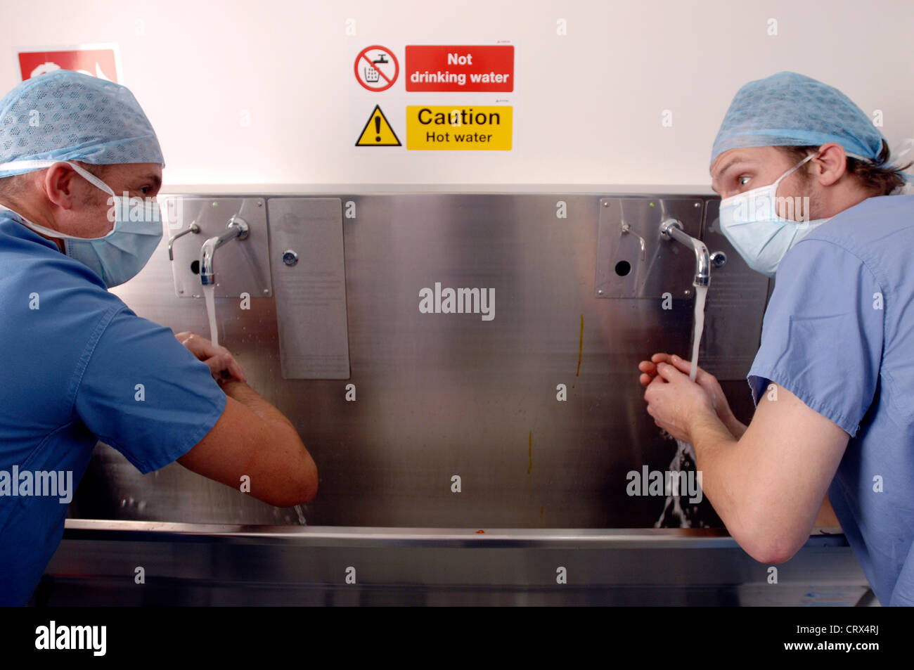 Rear view of two surgeons scrubbing up before an operation Stock Photo ...