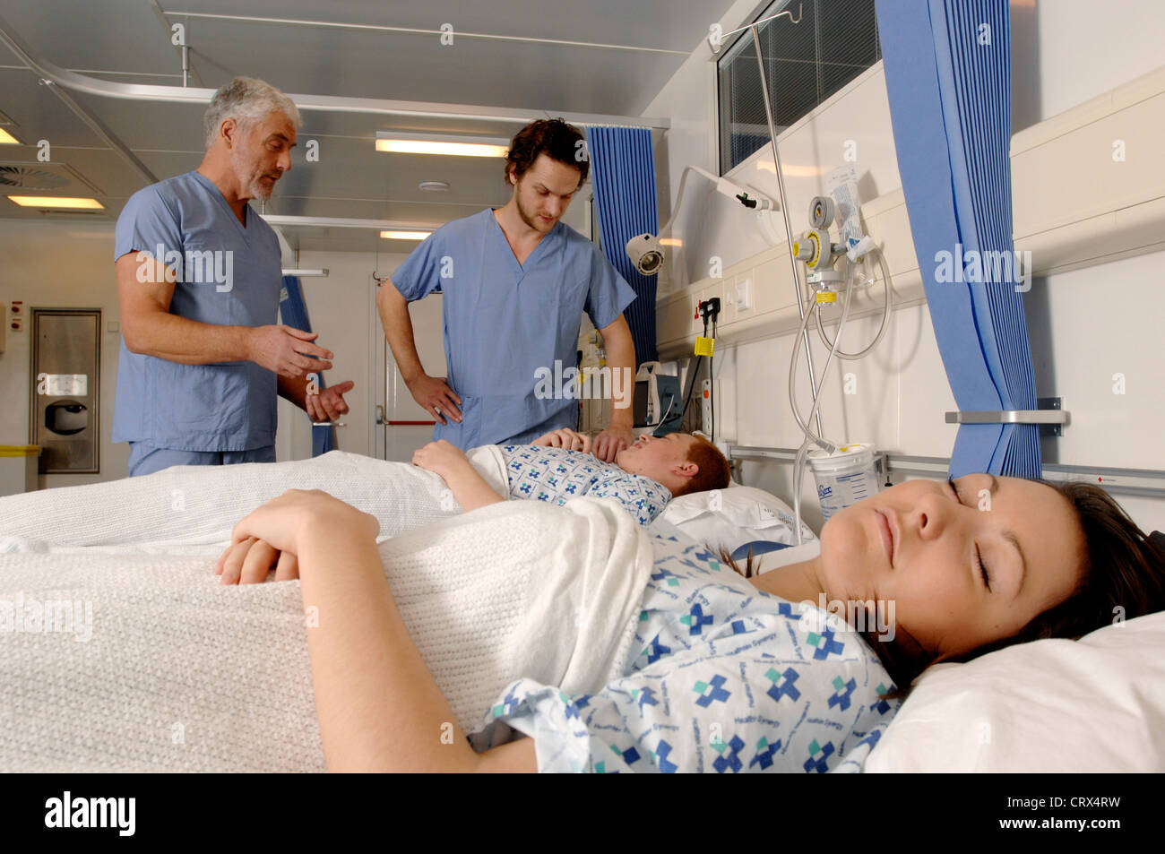 A surgeon (left) and a member of his surgical team talk with patients ...