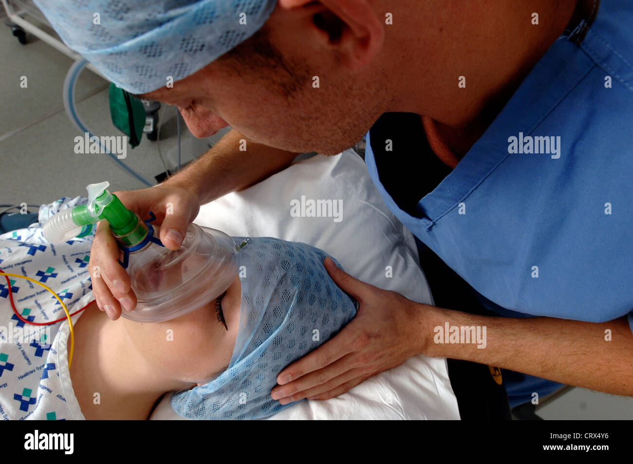 An anaesthetist administering medical gases to put a patient to sleep ...