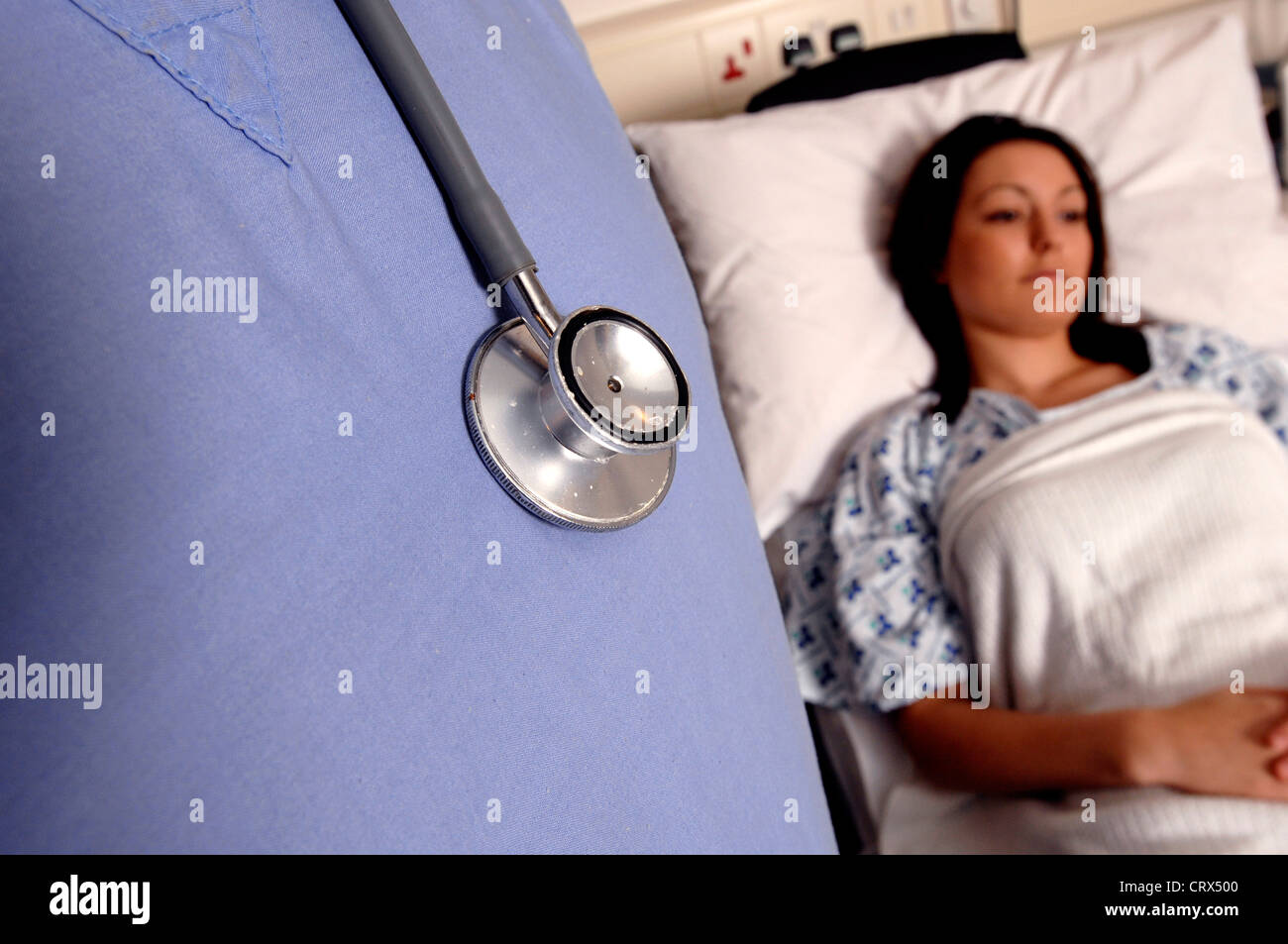 A doctor, with a stethoscope around his neck stands in front of a ...