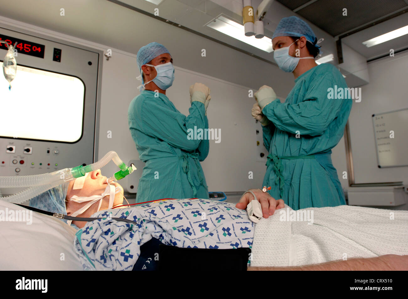 A young female patient, wearing a blue surgical cap, in an operating ...
