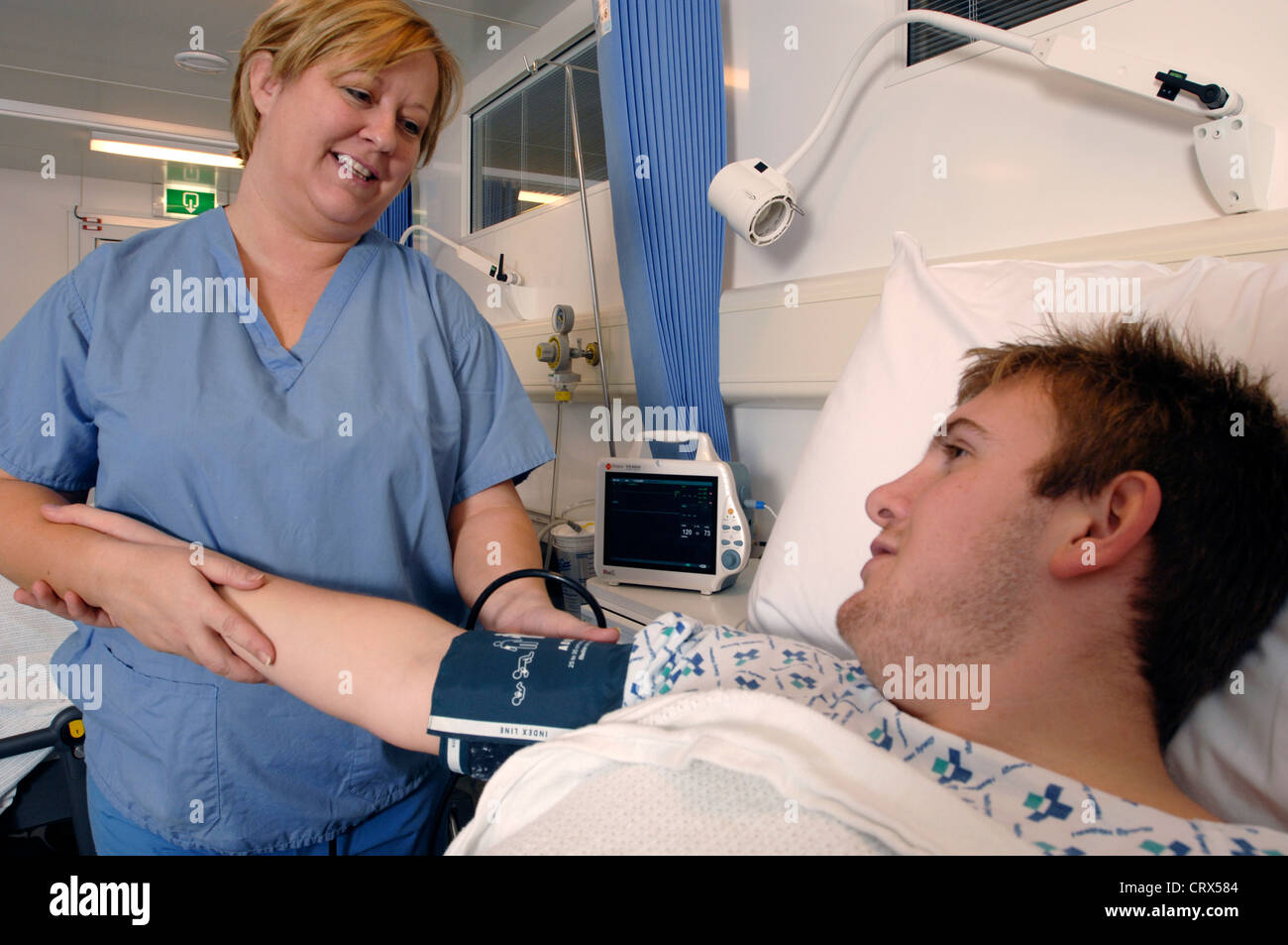A female nurse checking a patients blood pressure Stock Photo - Alamy