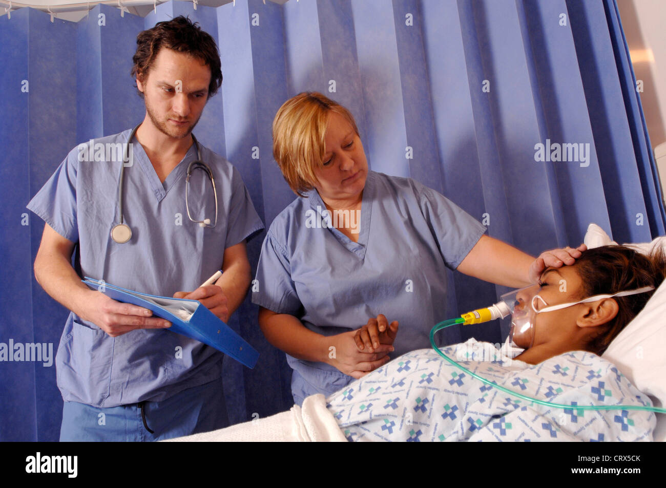 A doctor and a nurse on their ward rounds check the condition of a ...