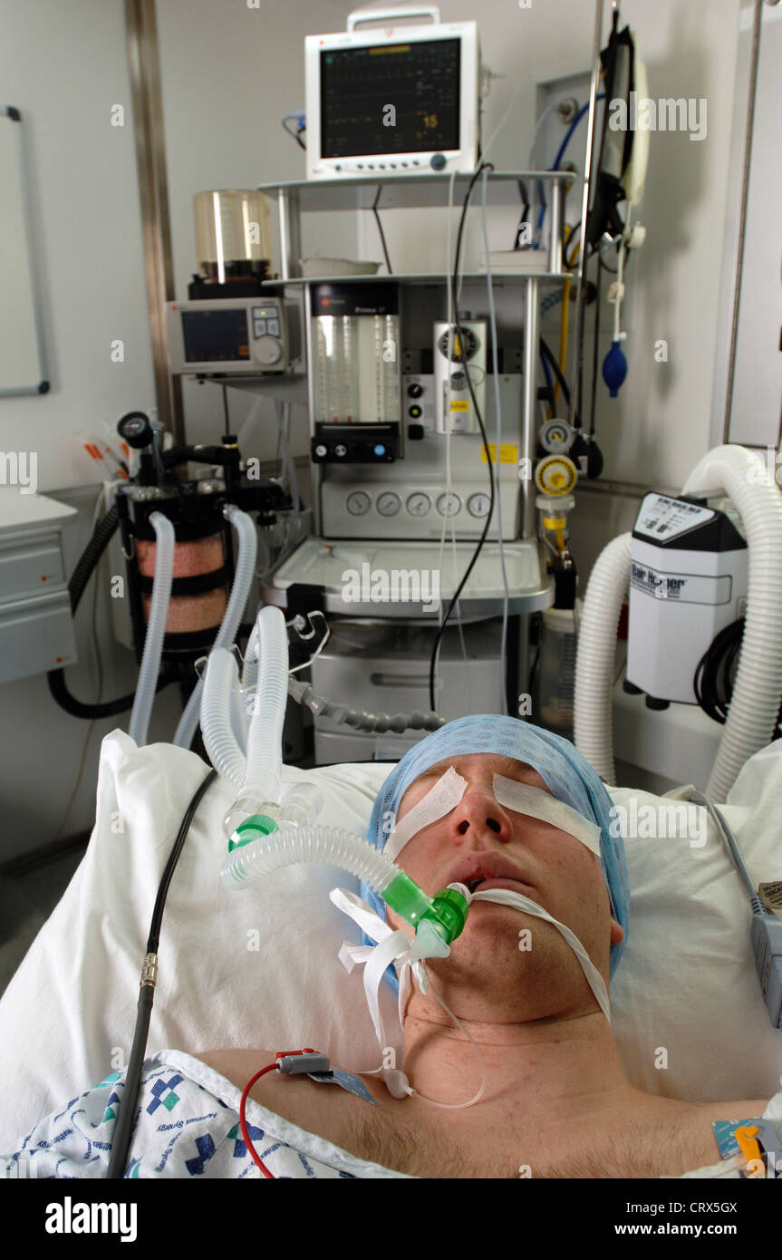 An anesthetized patient wired to electronic equipment to monitor his ...