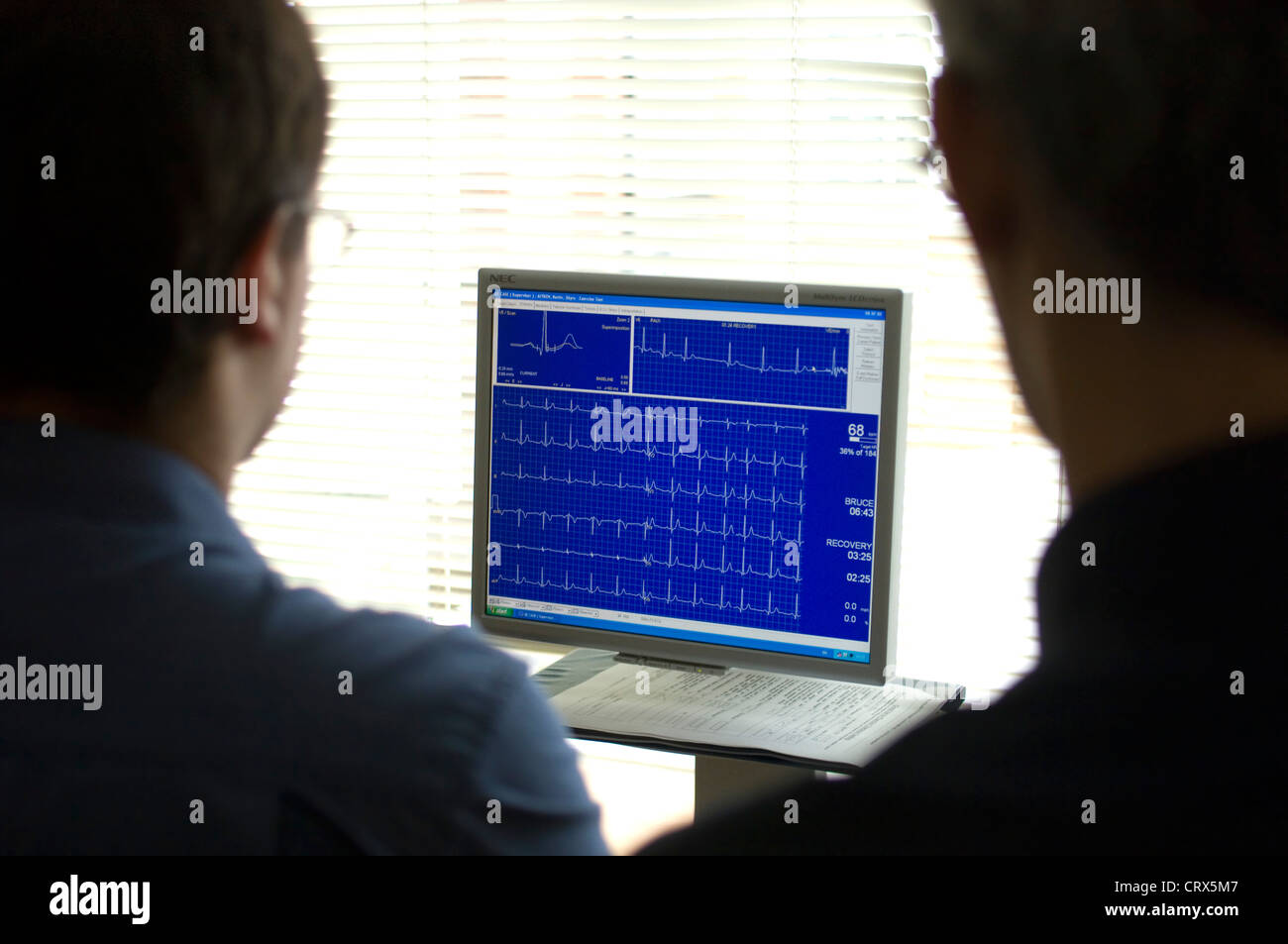 Two doctors looking at a monitor of a cardiogram Stock Photo - Alamy