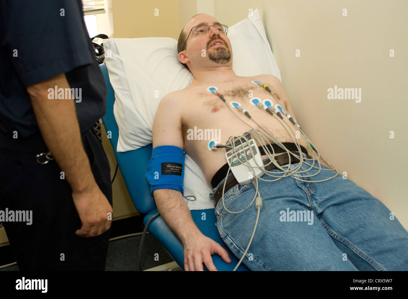 A man wired up to undergo an electrocardiogram to evaluate his cardiac ...