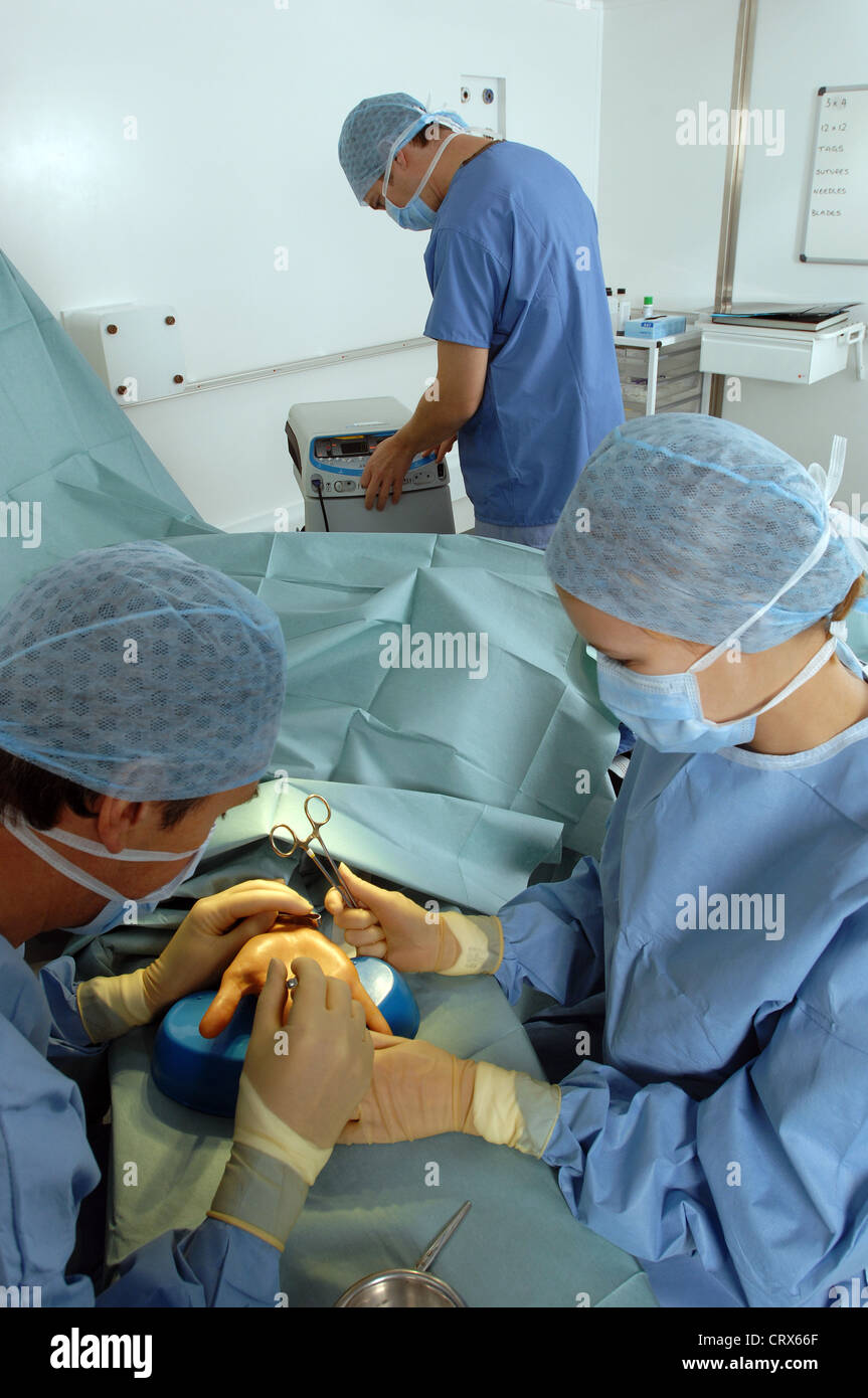 Surgeons operating on a patients hand Stock Photo - Alamy