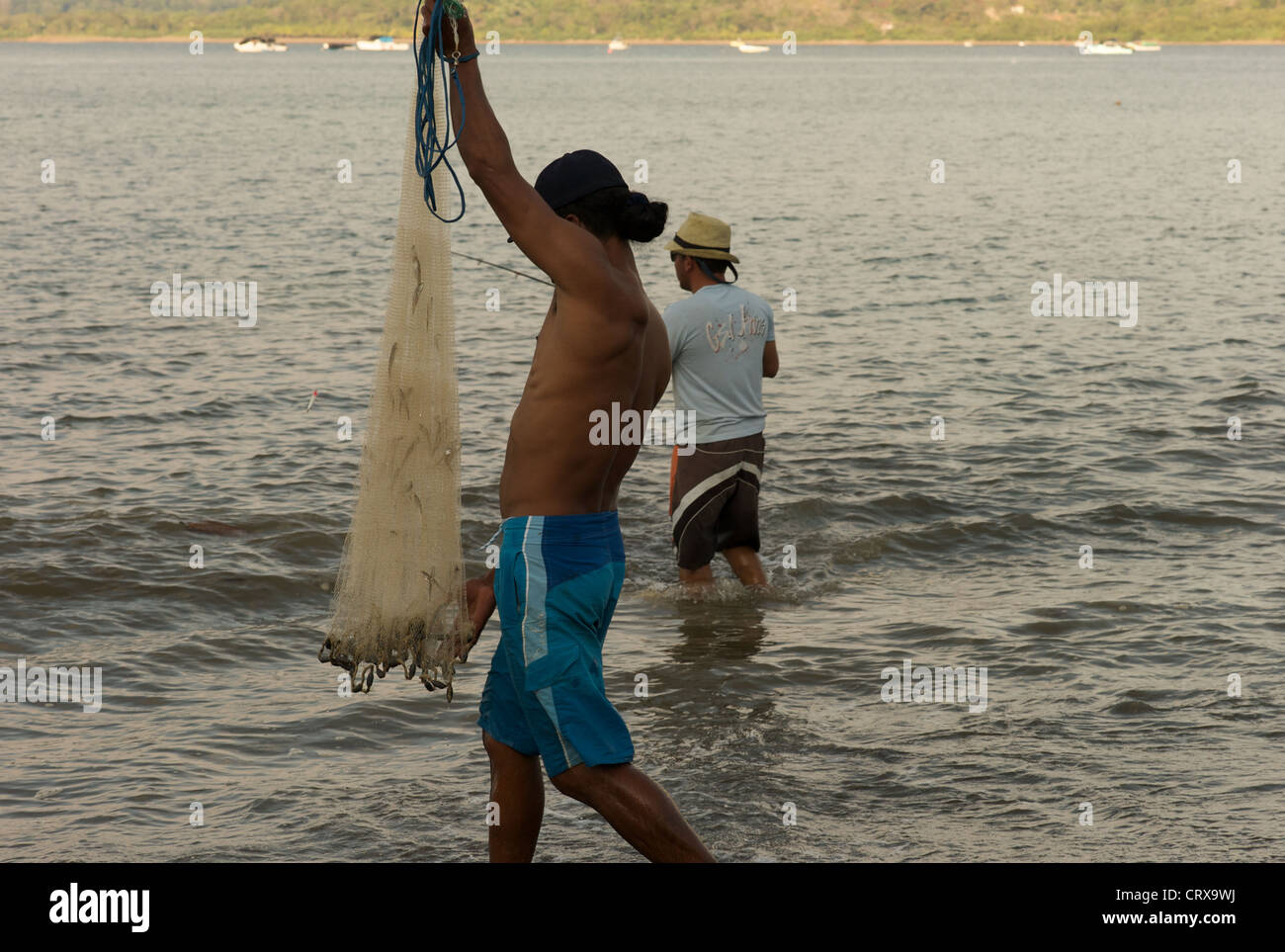 Fisherman with net in sea Stock Photo - Alamy