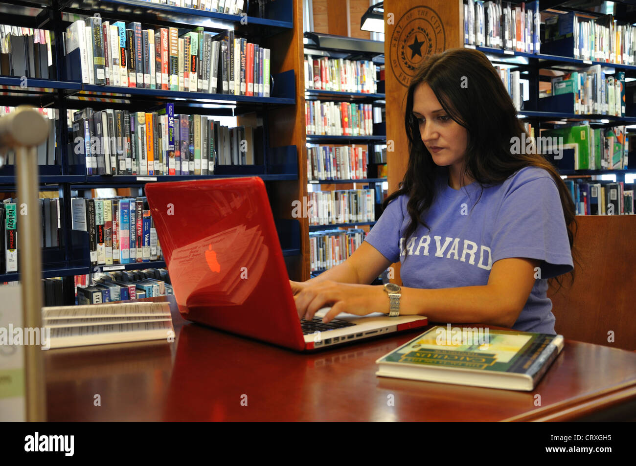Student in library with laptop Stock Photo - Alamy