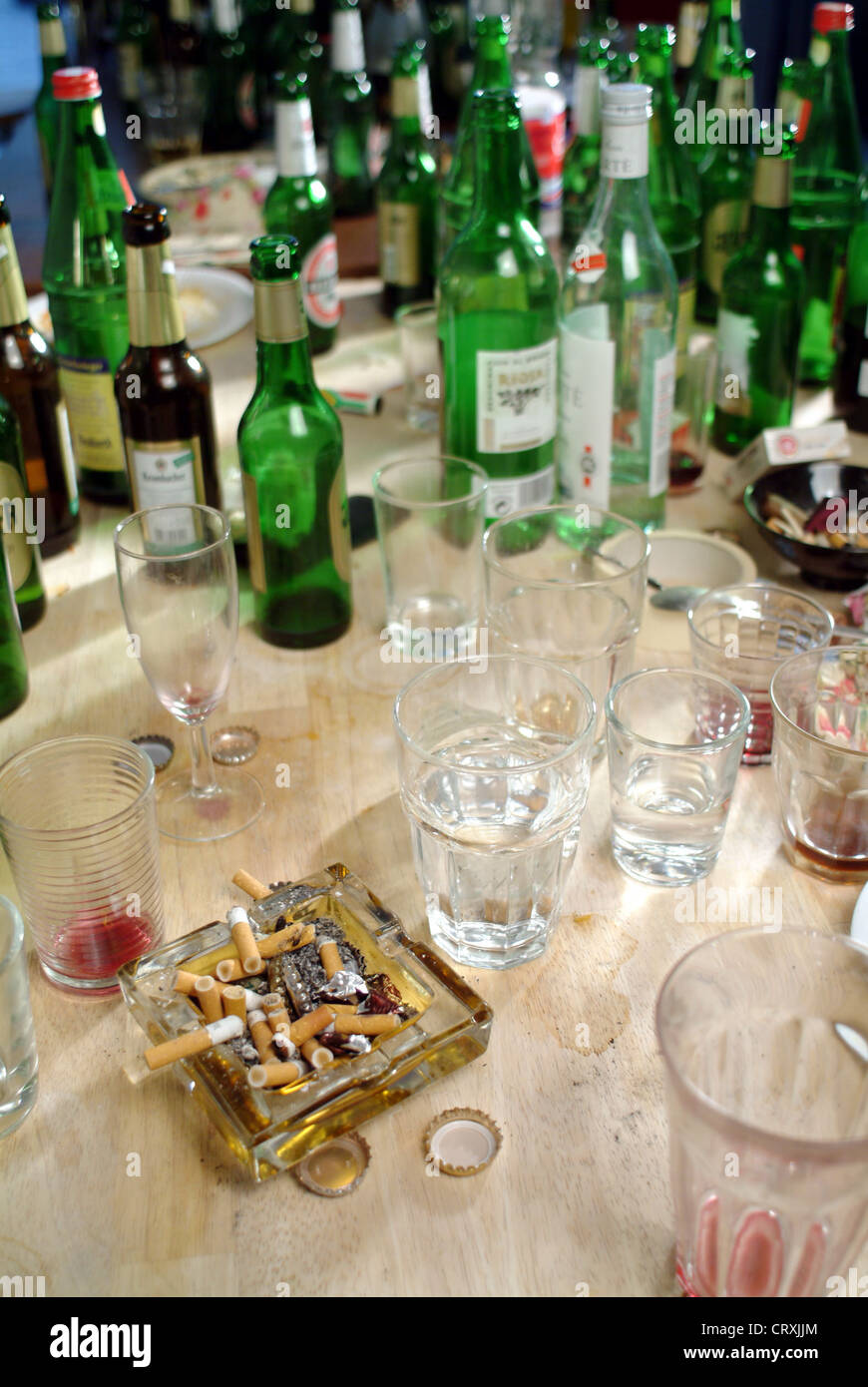 Table full of bottles and a full ashtray Stock Photo - Alamy