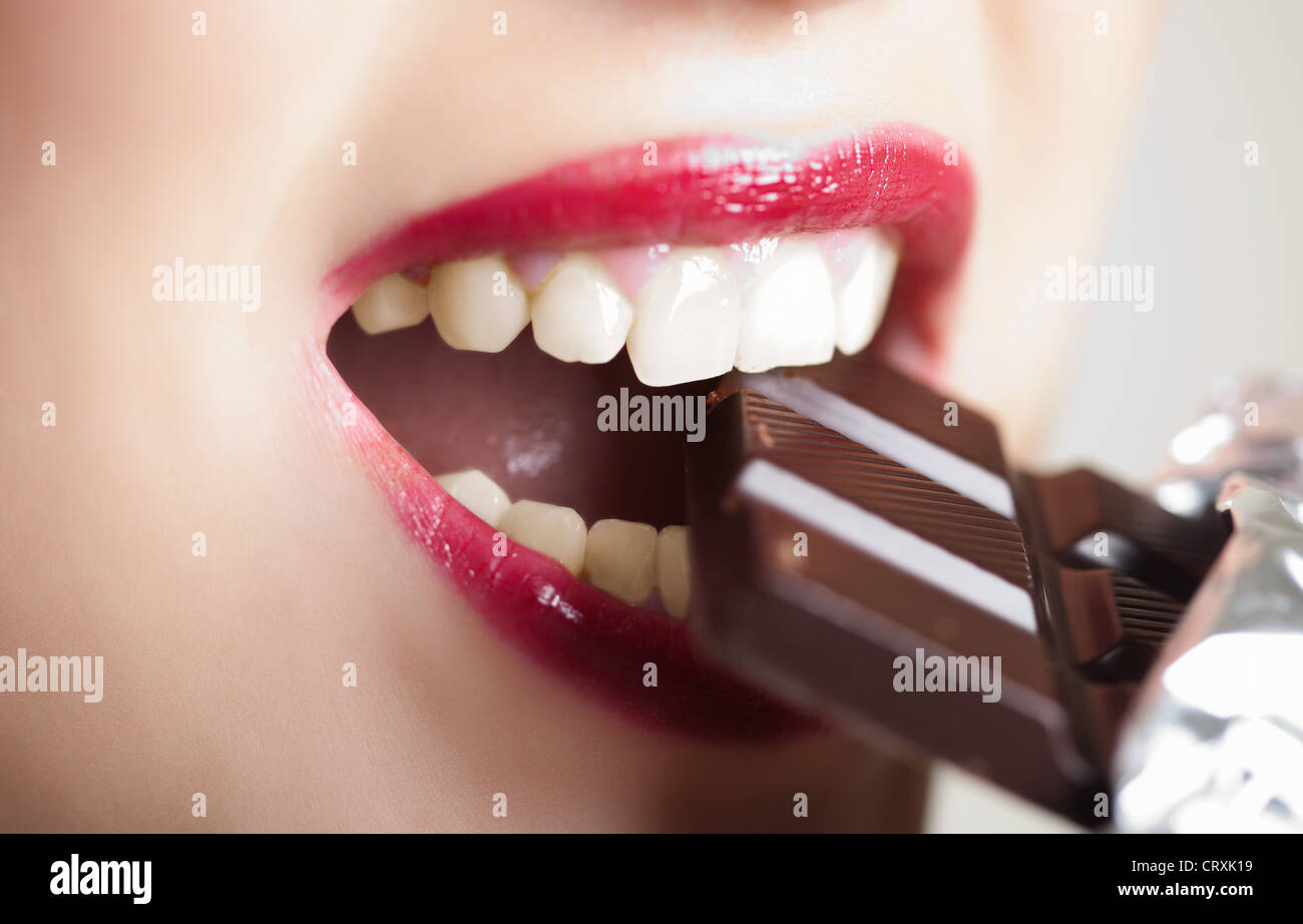 closeup view on woman mouth biting chocolate Stock Photo - Alamy