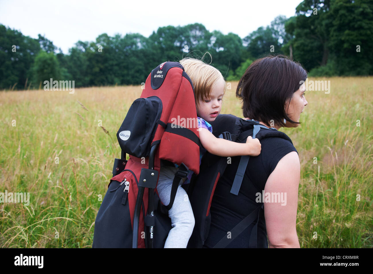A woman mother carries her child in a backpack outdoor Stock Photo - Alamy