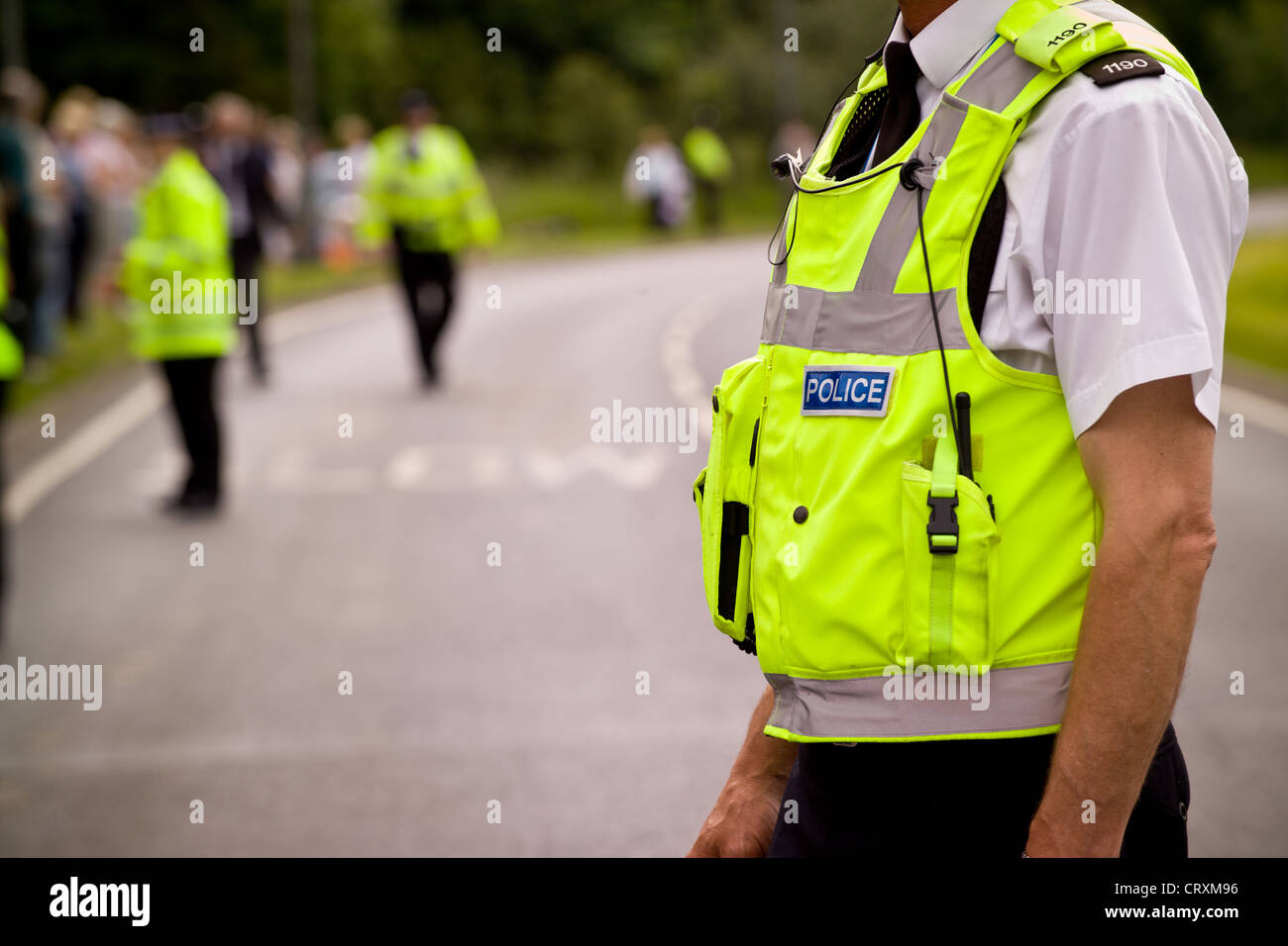 Unidentifiable police marshalling public along roadside during royal ...