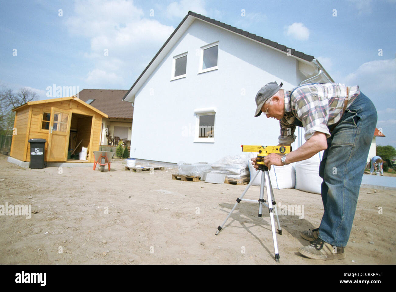 Man measuring his own homes plot Stock Photo - Alamy