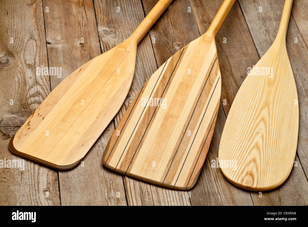 blades of three wooden canoe paddles of different shape against grunge ...