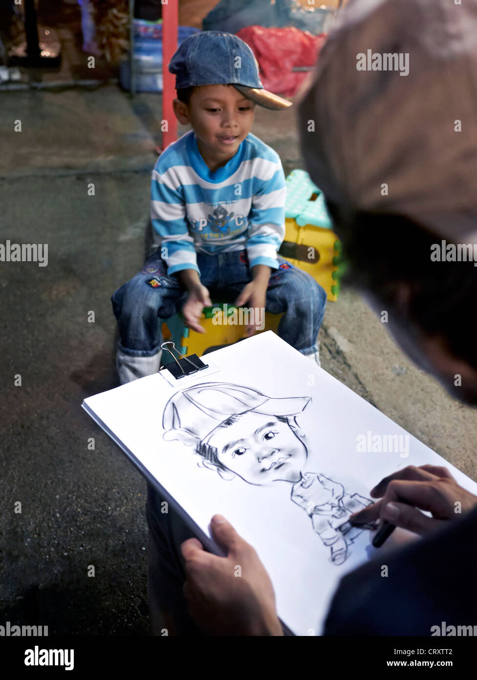 Artist drawing portrait of cute young boy Stock Photo - Alamy
