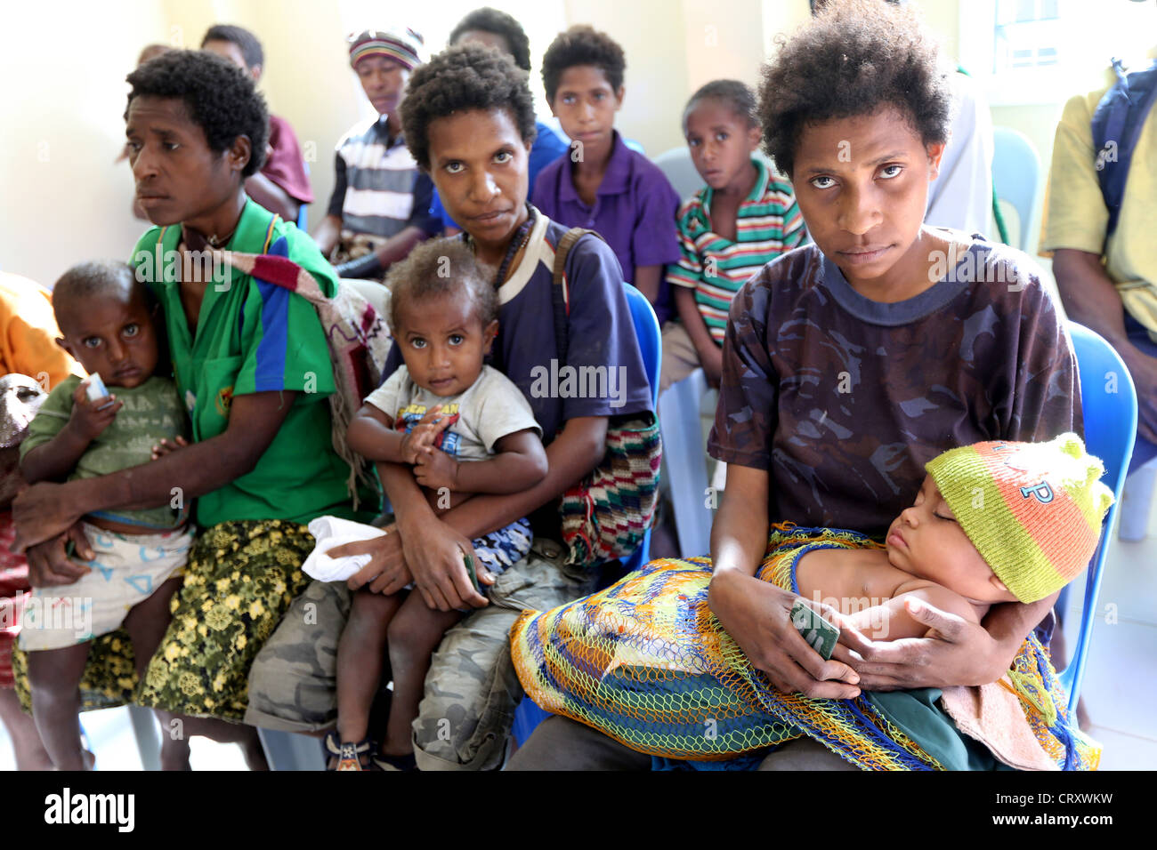 Mothers with their children wait in a hospital of a village in Papua ...