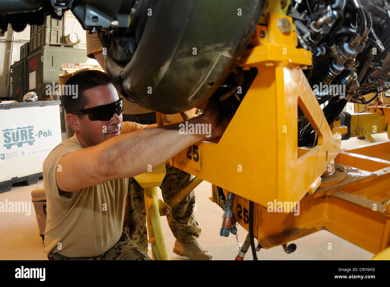 U.S. Army Sgt. Michael Johnson, an engine mechanic, works on the engine ...