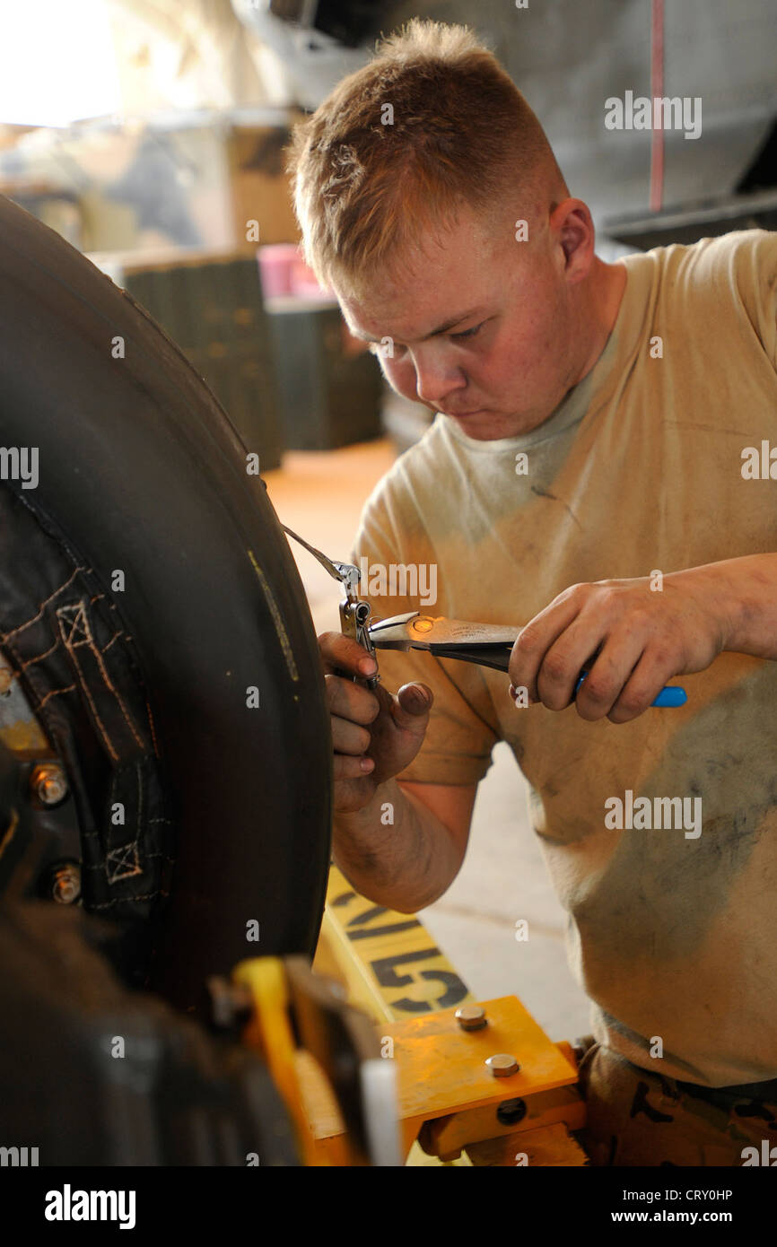 U.S. Army Spc. Jeremy Wilkey, a Chinook mechanic, works on the engine ...