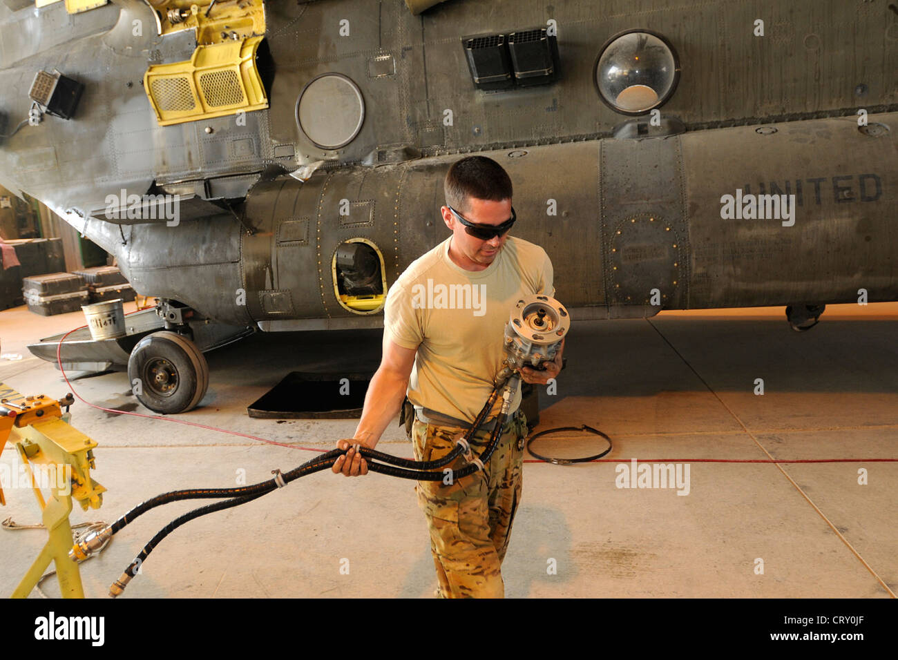 U.S. Army Sgt. Michael Johnson, an engine mechanic, works on the engine ...