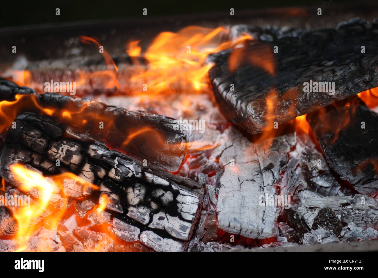 Burning logs with flames and ash Stock Photo - Alamy