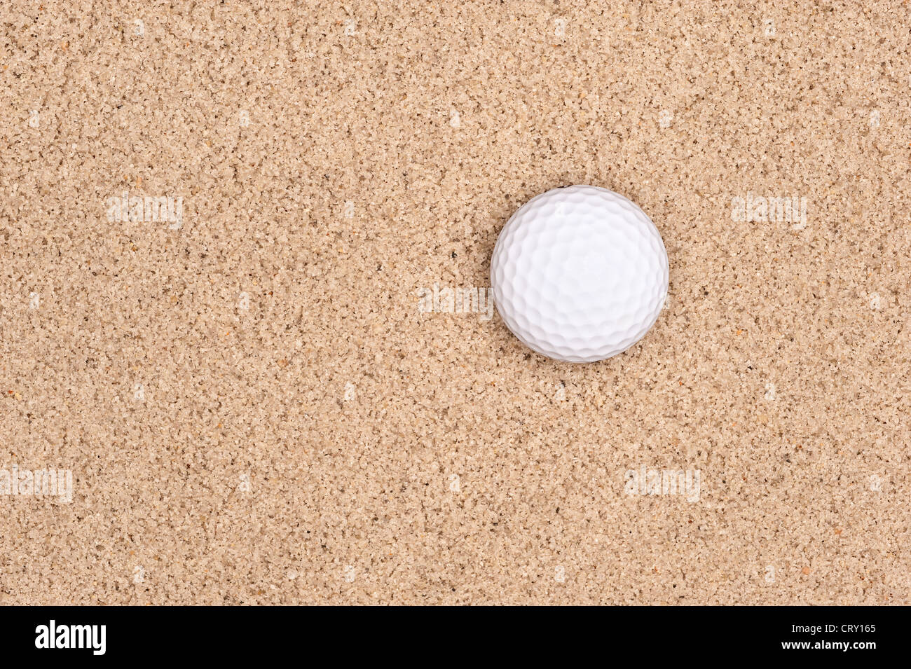A lone golf ball in a sand trap looking top down with plenty of room ...