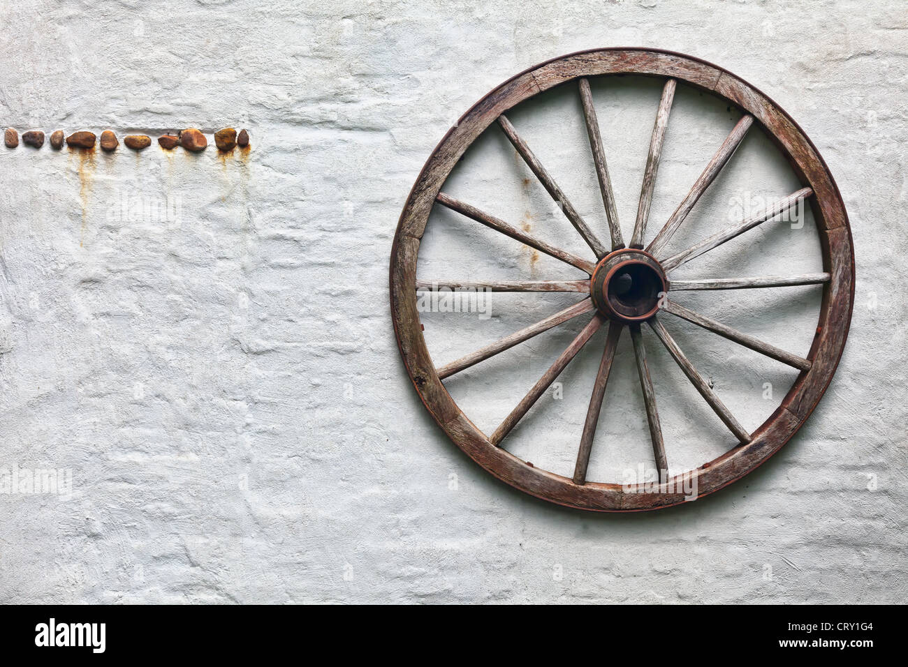 Rustic wagon wheel hanging on a wall Stock Photo - Alamy