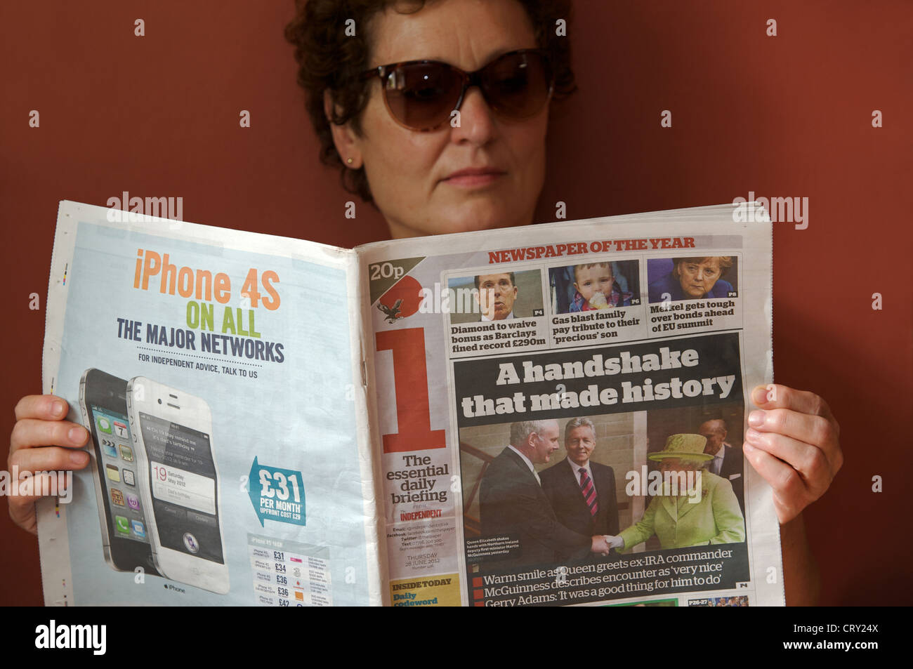 Woman reading a copy of the i Independent newspaper Stock Photo - Alamy