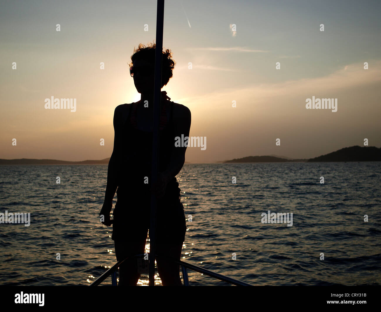 Girl's silhouette on a sailing boat at the sunset Stock Photo - Alamy