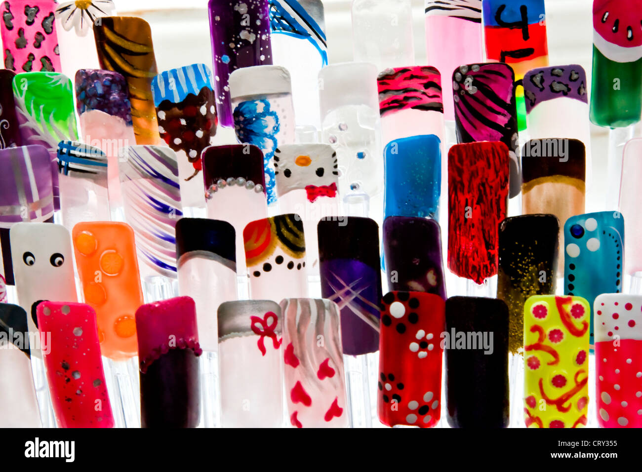 A selection of colourful, individual, hand painted fake finger nails ...