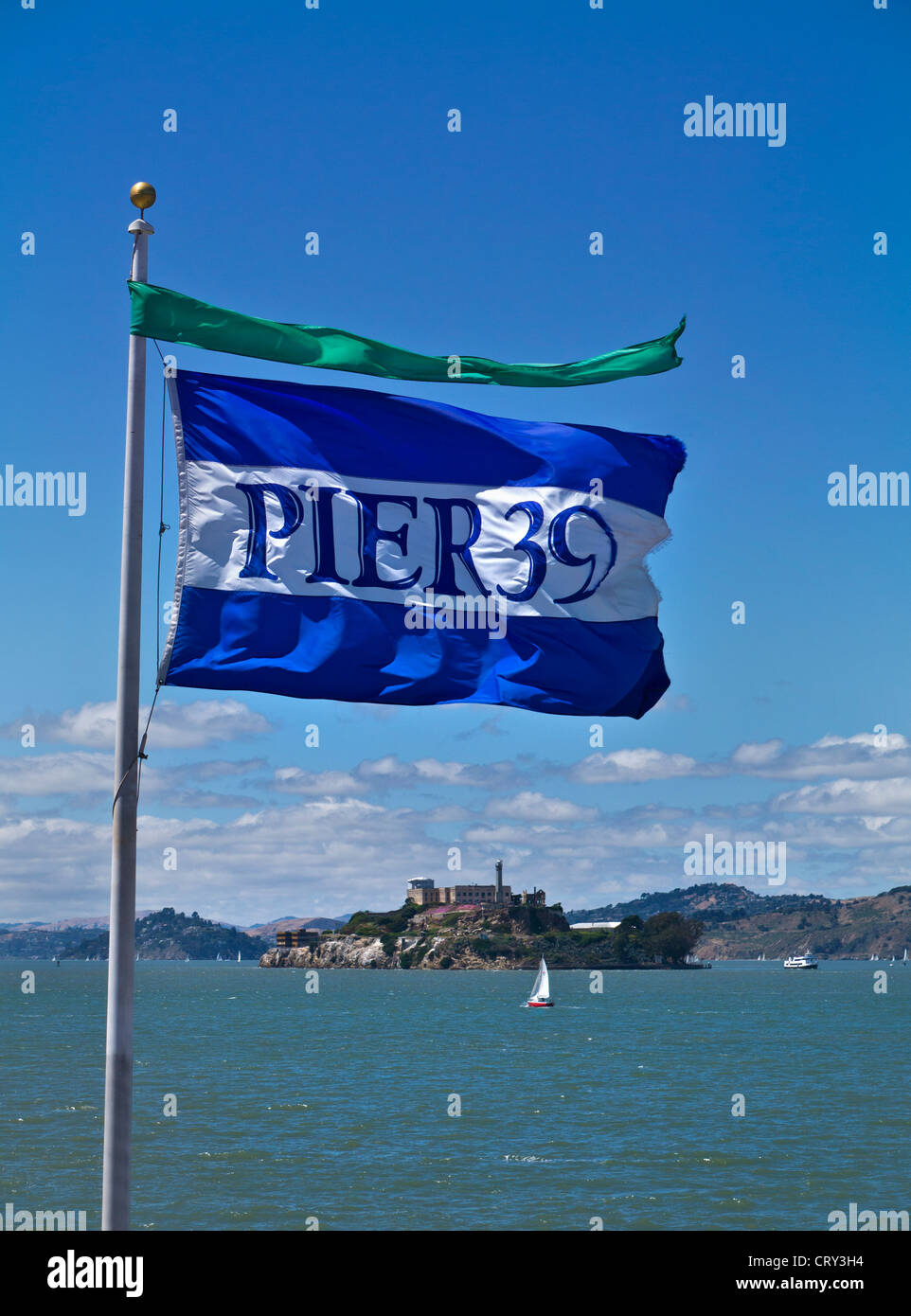 Pier 39 flag in sea breeze with Alcatraz prison island attraction and ...