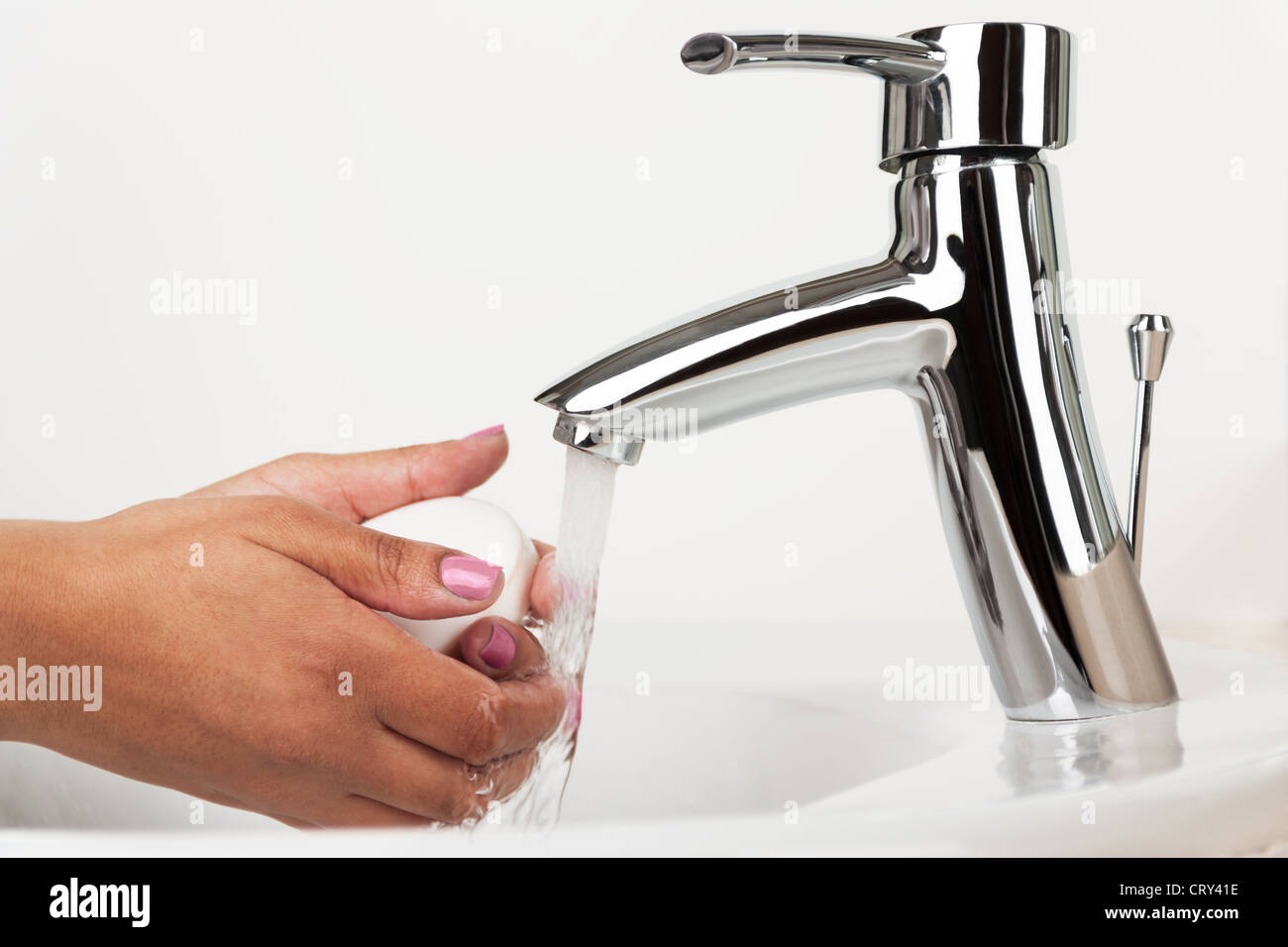 Woman washing hands with soap and water under tap in bathroom Stock ...
