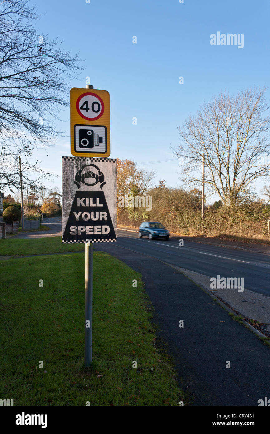 Multiple road signs in a suburban area: 40mph, speed camera trap, "Kill ...