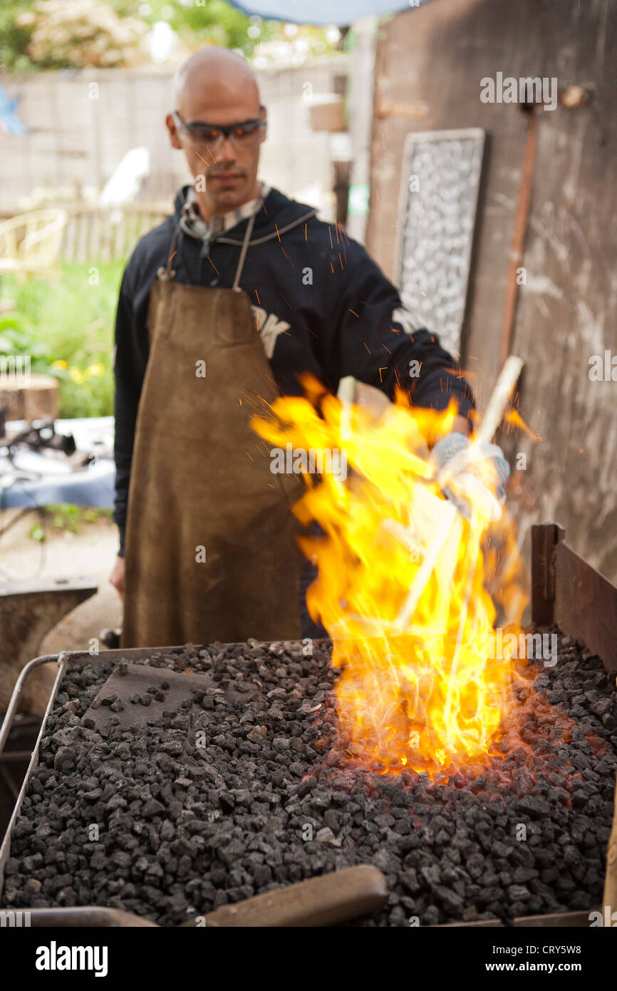 blacksmith making decorative iron work using a hammer and anvil Stock ...