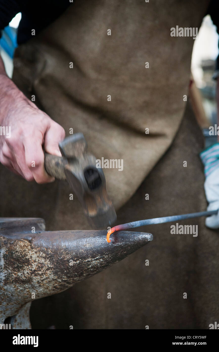 Blacksmith making decorative iron work using hammer and anvil Stock ...