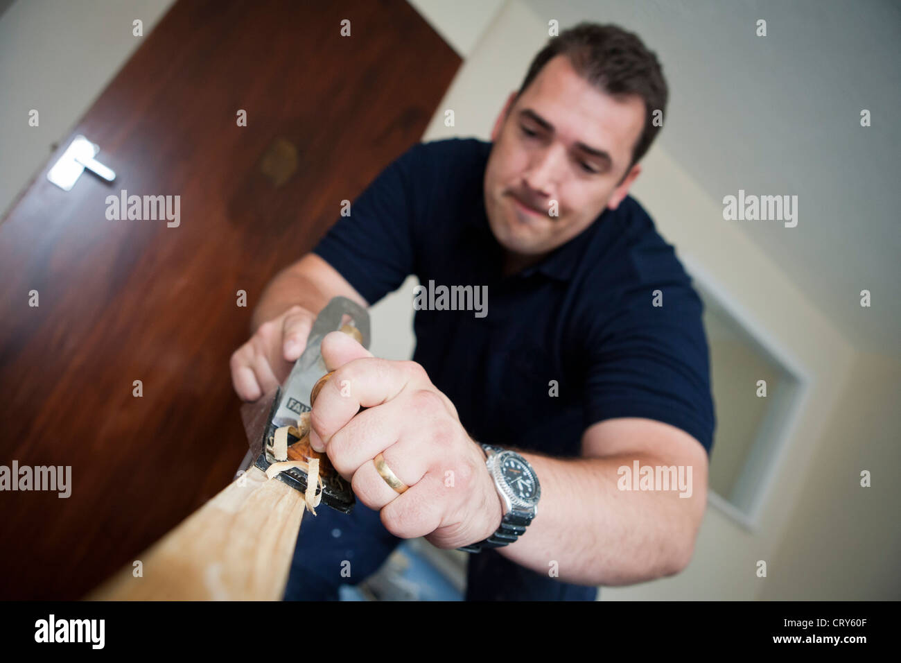 Workman planing door ready to be hung Stock Photo - Alamy