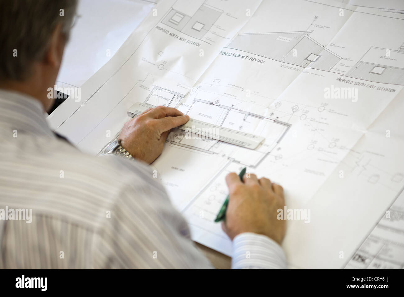 Surveyor takes measurements from building plans Stock Photo - Alamy