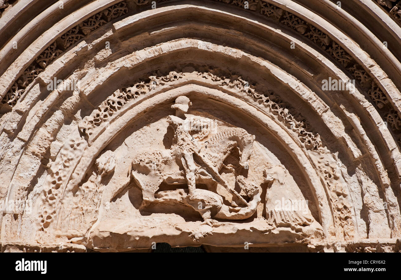 A12c carving of St George and the Dragon over the door to the church of ...