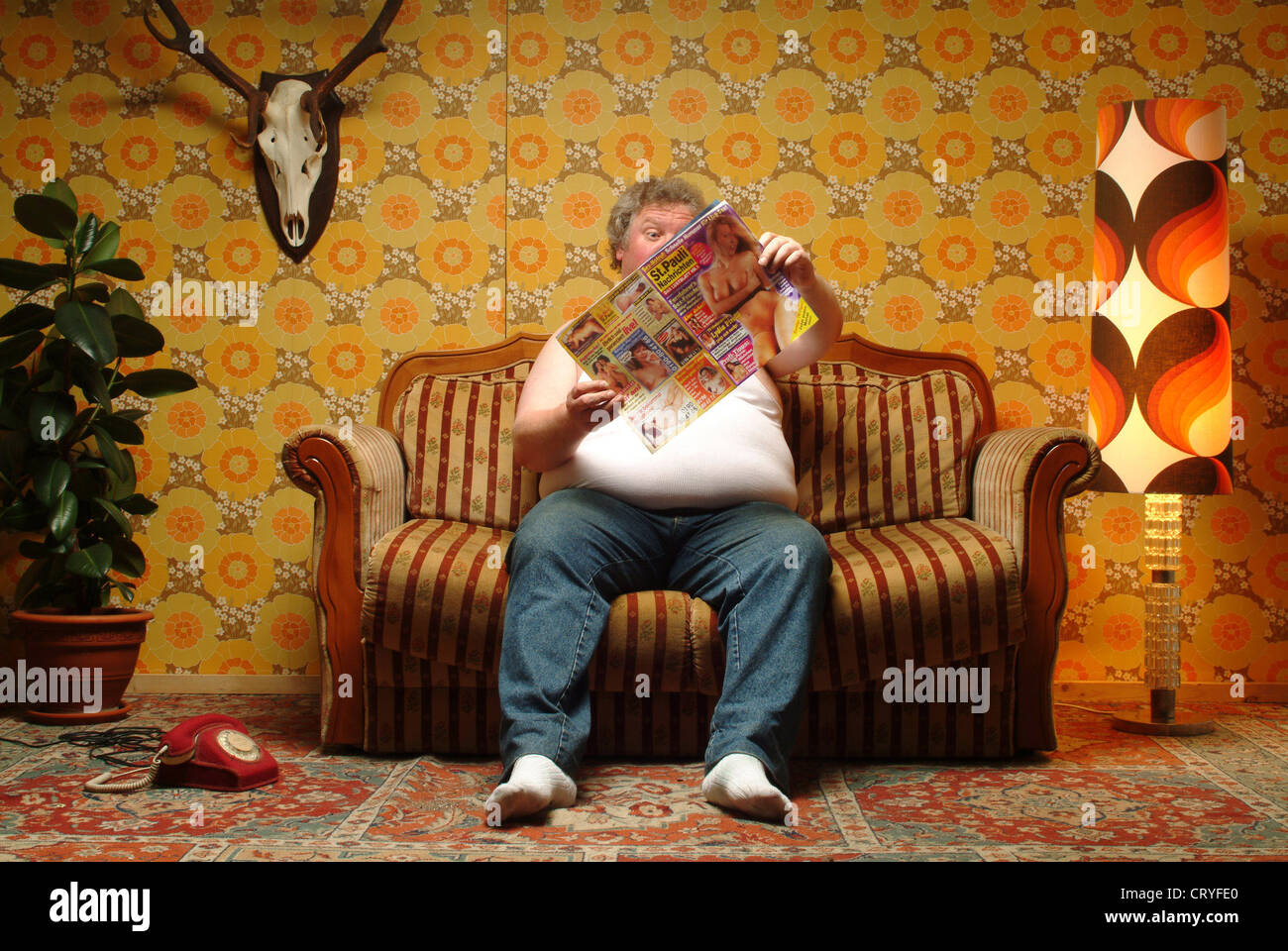 A fat man with Sexheftchen on the couch Stock Photo - Alamy
