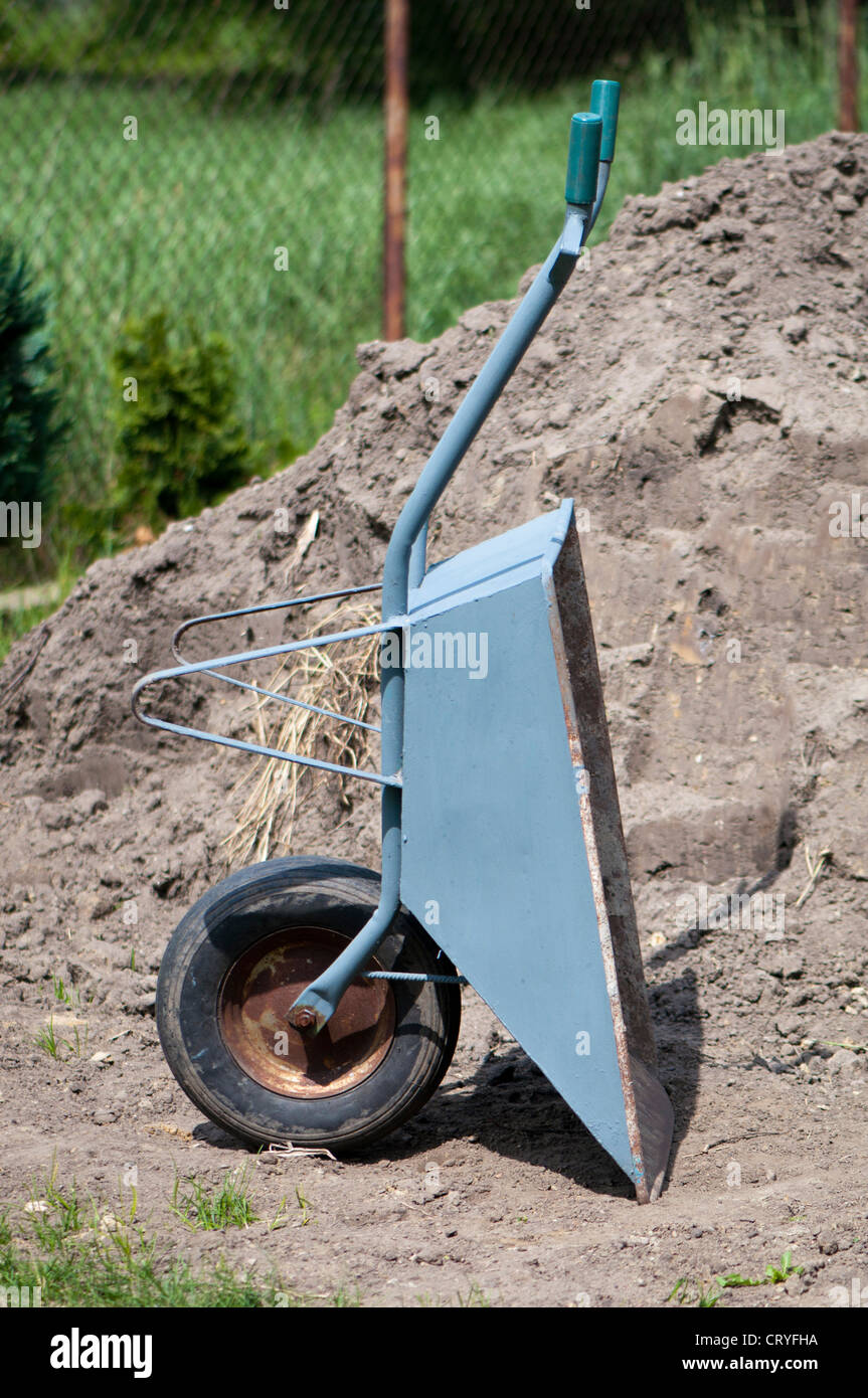 wheelbarrow on the background of the mound of sand Stock Photo - Alamy