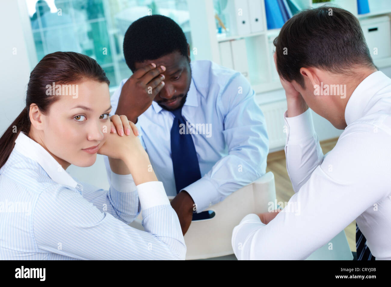 Portrait of sad business team sitting in office Stock Photo - Alamy