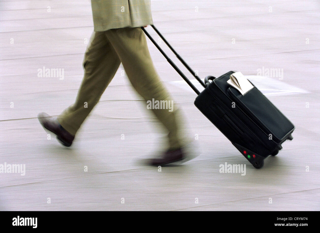 Running legs of a man with a suitcase and a newspaper Stock Photo - Alamy