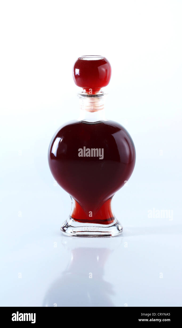 Bottle of red liqueur on shiny background Stock Photo - Alamy