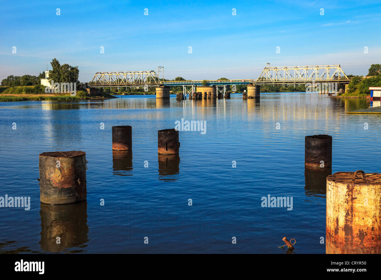 Piles of an old jetty on the background of the railway bridge Stock ...