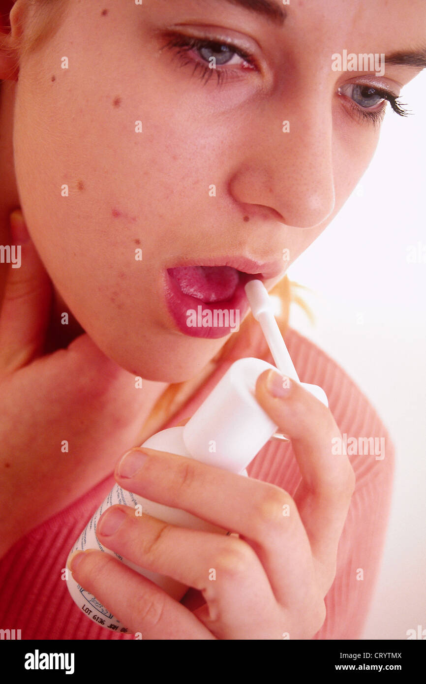 ADOLESCENT USING SPRAY IN MOUTH Stock Photo - Alamy