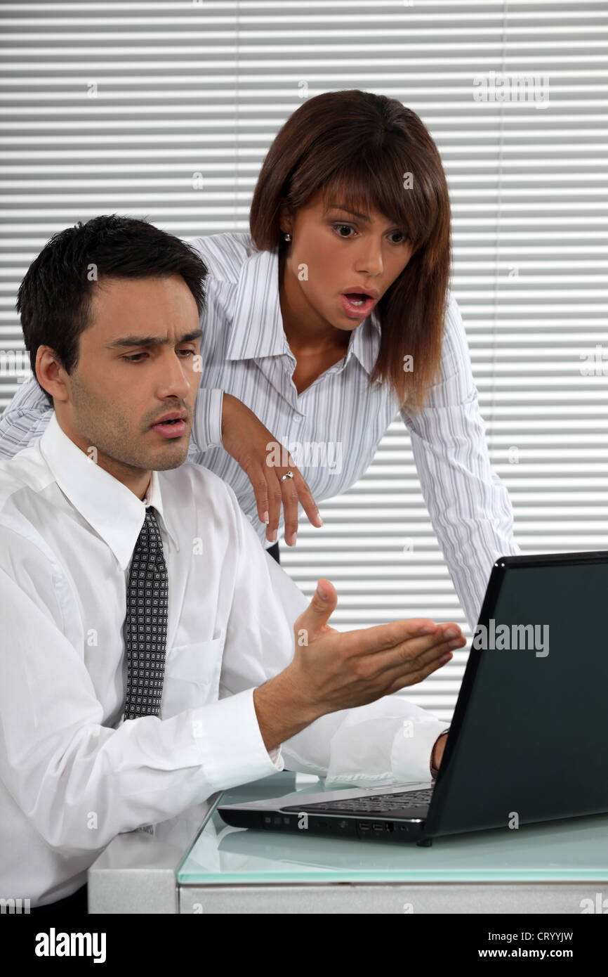 Two businessworkers shocked by laptop screen Stock Photo - Alamy