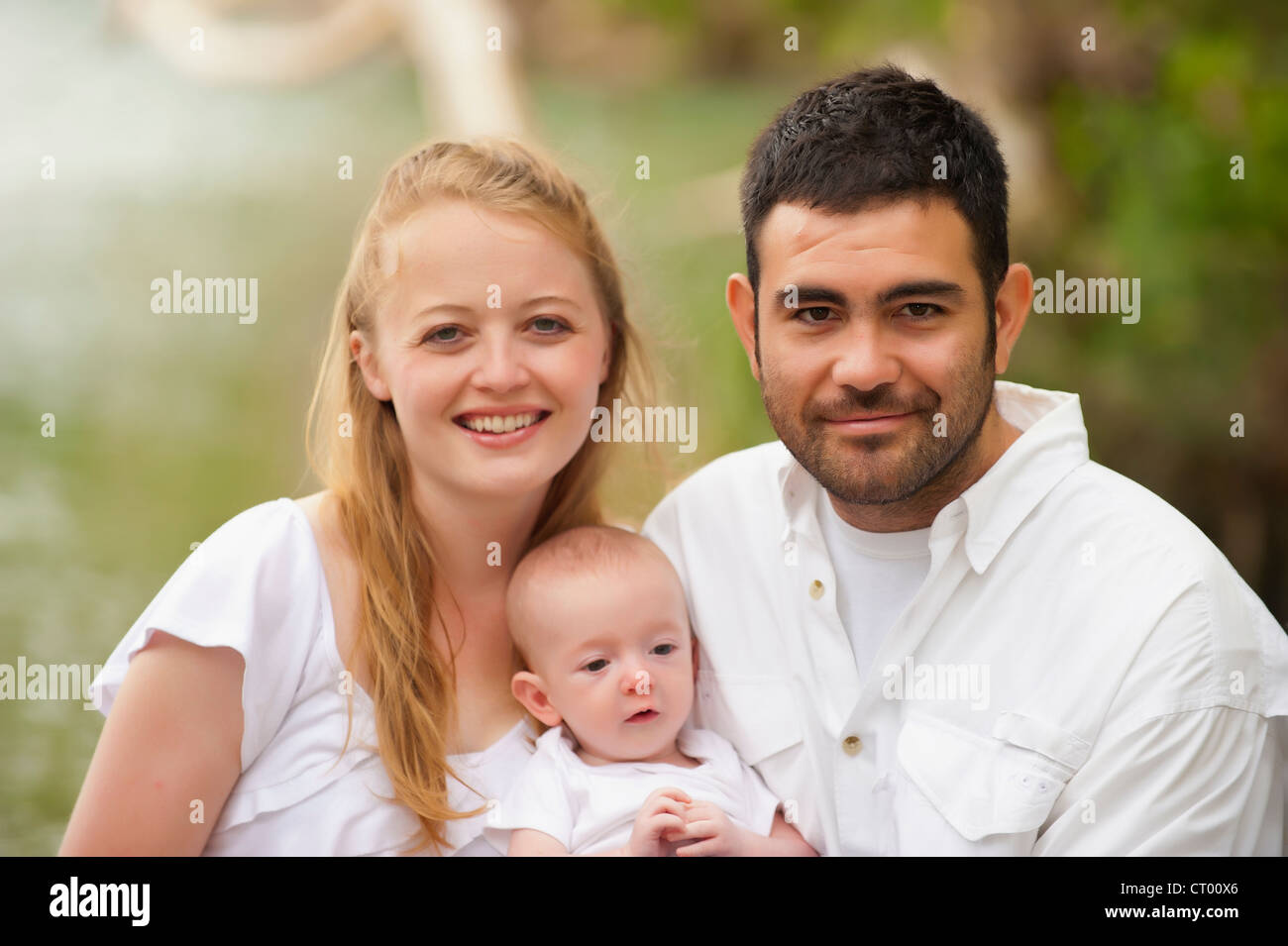 Happy parents with baby boy in a park Stock Photo - Alamy