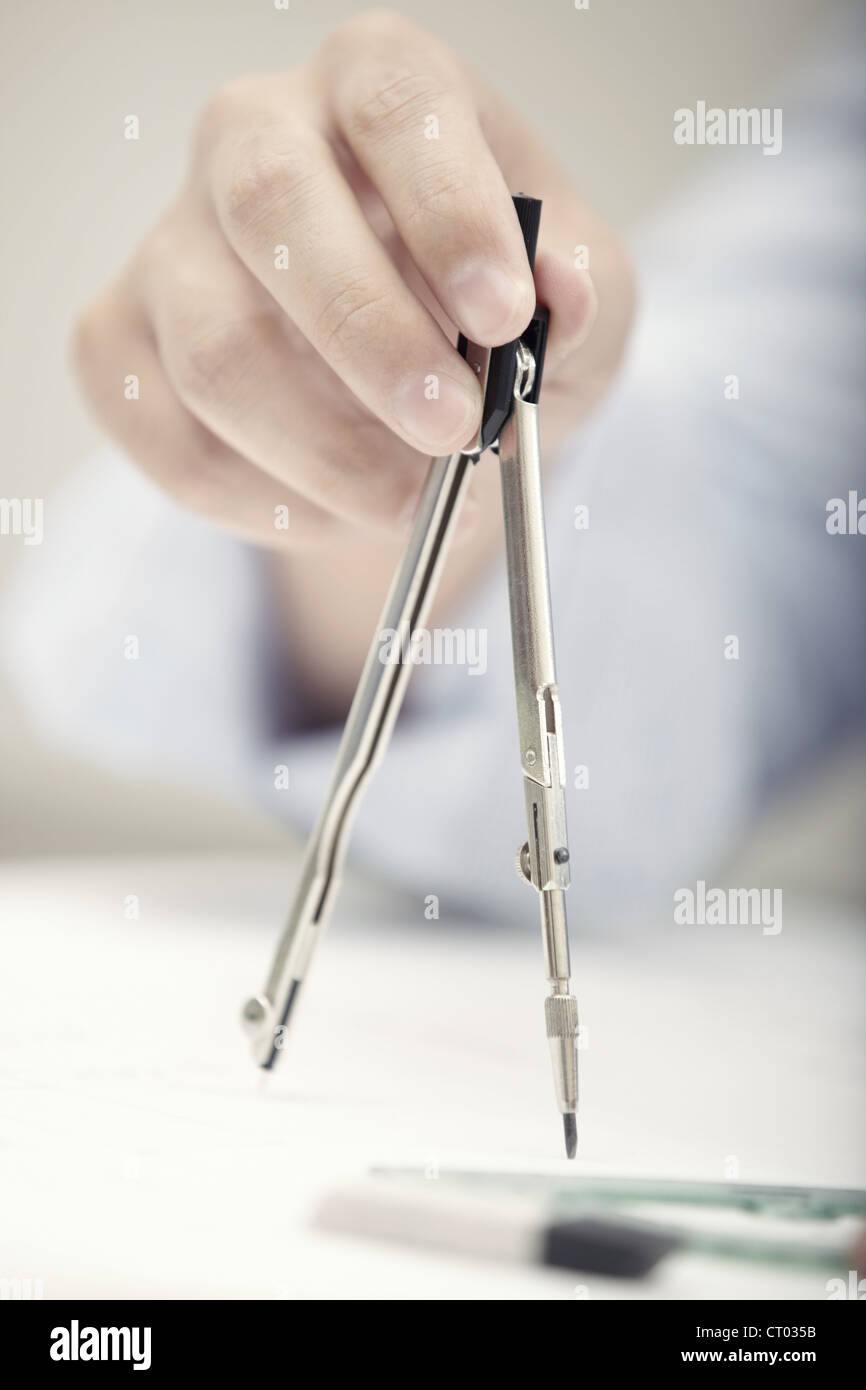Hand of engineer working with compasses Stock Photo - Alamy