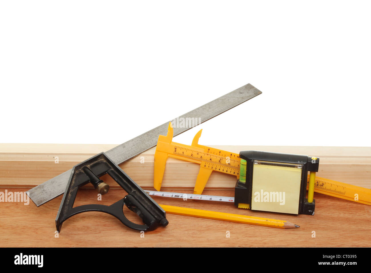 Selection of woodwork measuring tools on timber against a white ...