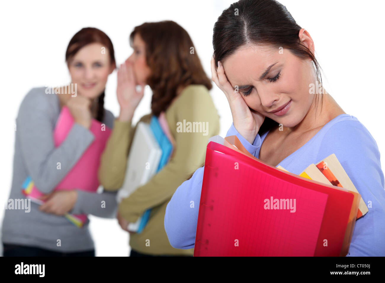 women whispering behind a confused colleague Stock Photo - Alamy